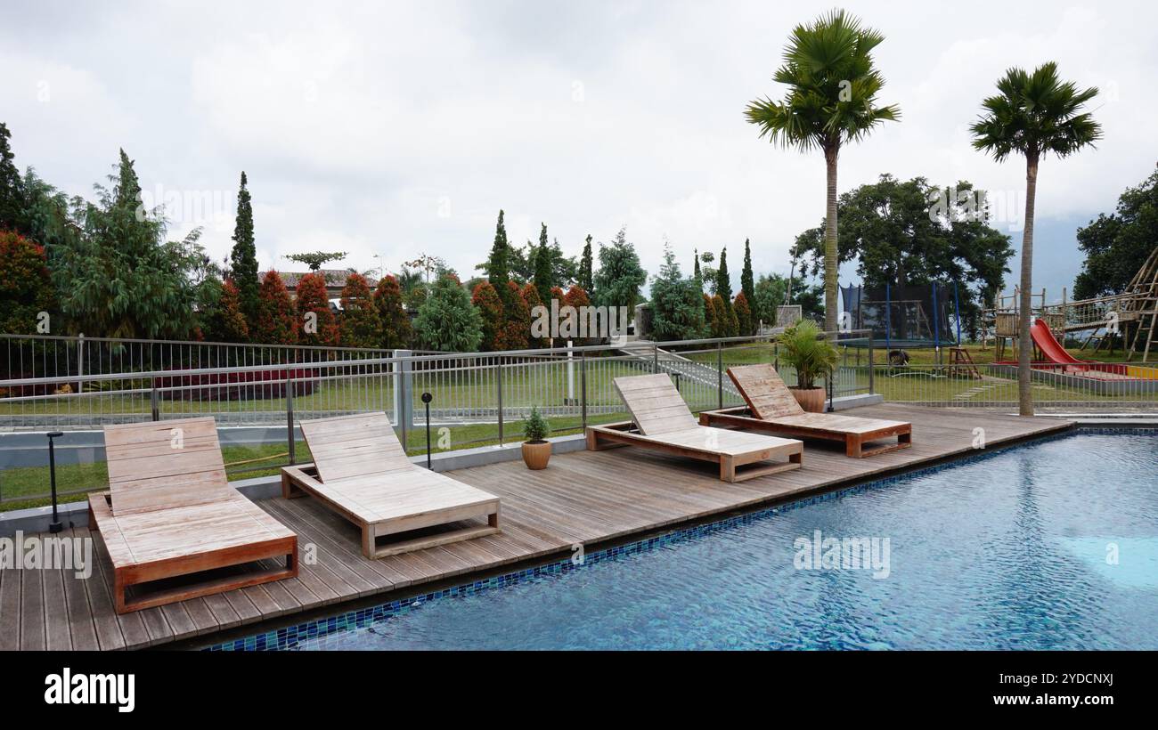 Beautiful clean swimming pool with four pool chairs in a highland ...