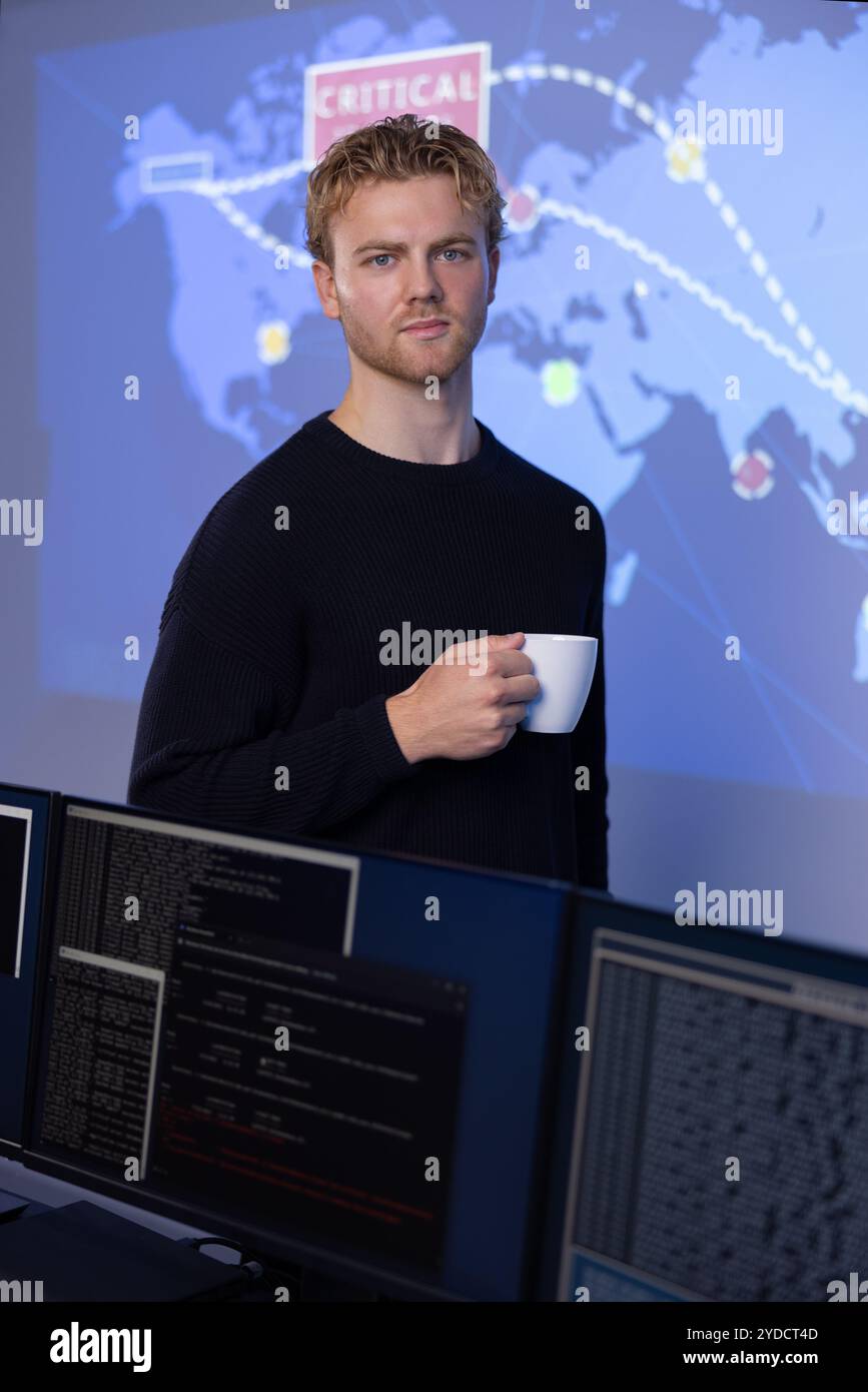 Confident male Cybersecurity Analyst with coffee cup in large Cyber ...