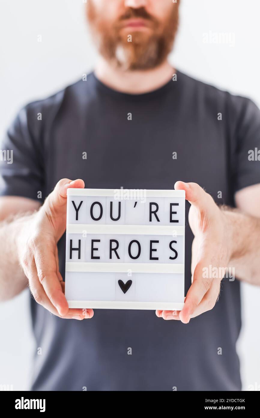 Nurse day concept. Man hands holding lightbox with You are heroes text ...