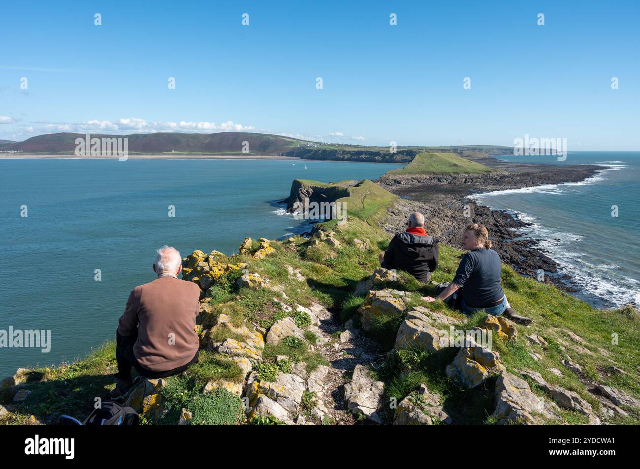 Group of three people looking back to the mainland from the Outer Head ...
