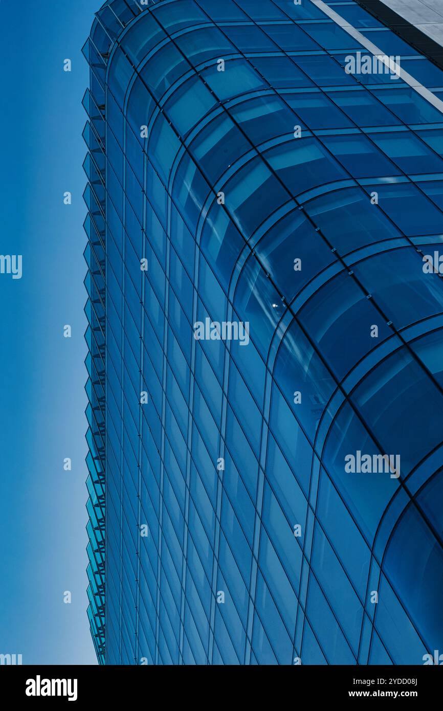 A low-angle shot of a modern glass building, showing the corner with a ...