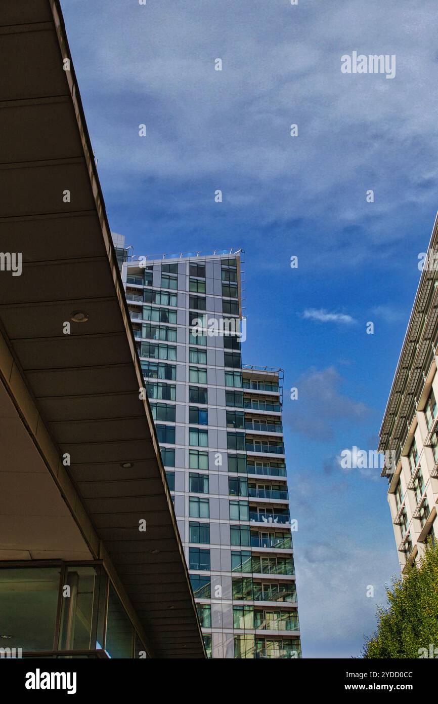 A tall, modern building with a glass facade is partially obscured by an ...