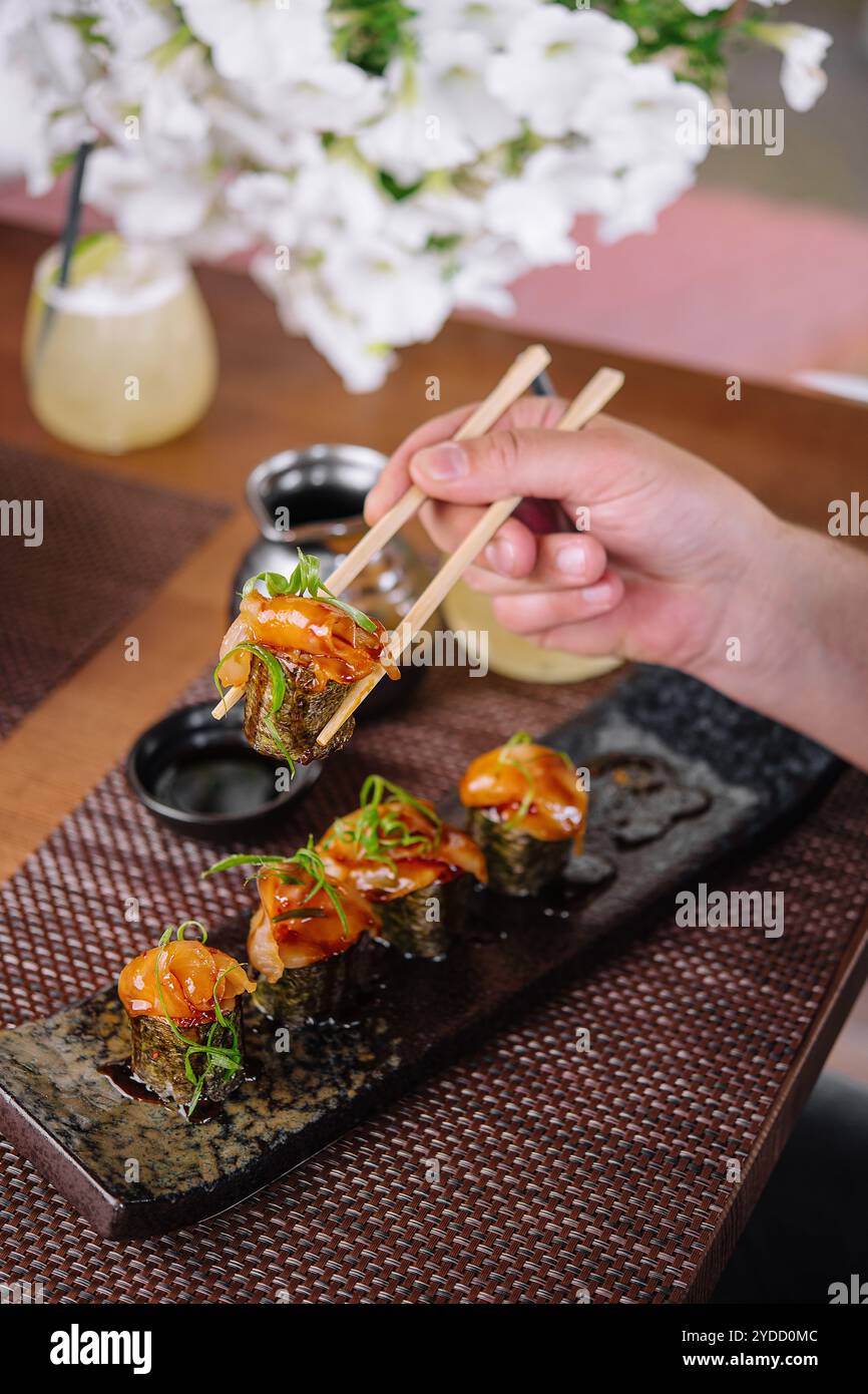Girl eats Japanese sushi gunkan salmon Stock Photo - Alamy