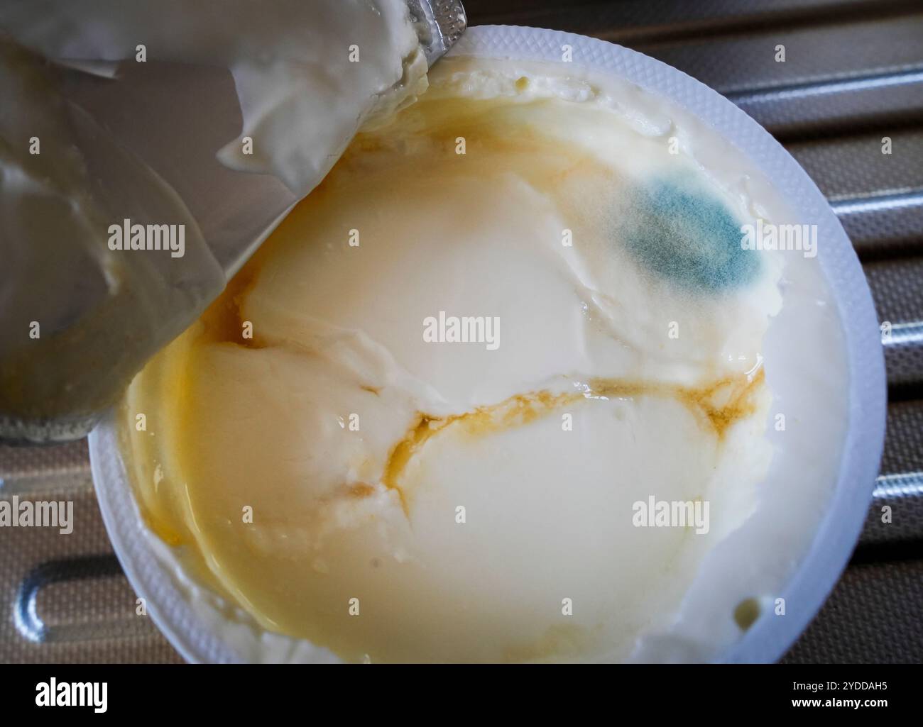 Product shoot detail close up of moldy uneadable yogurt in plastic ...