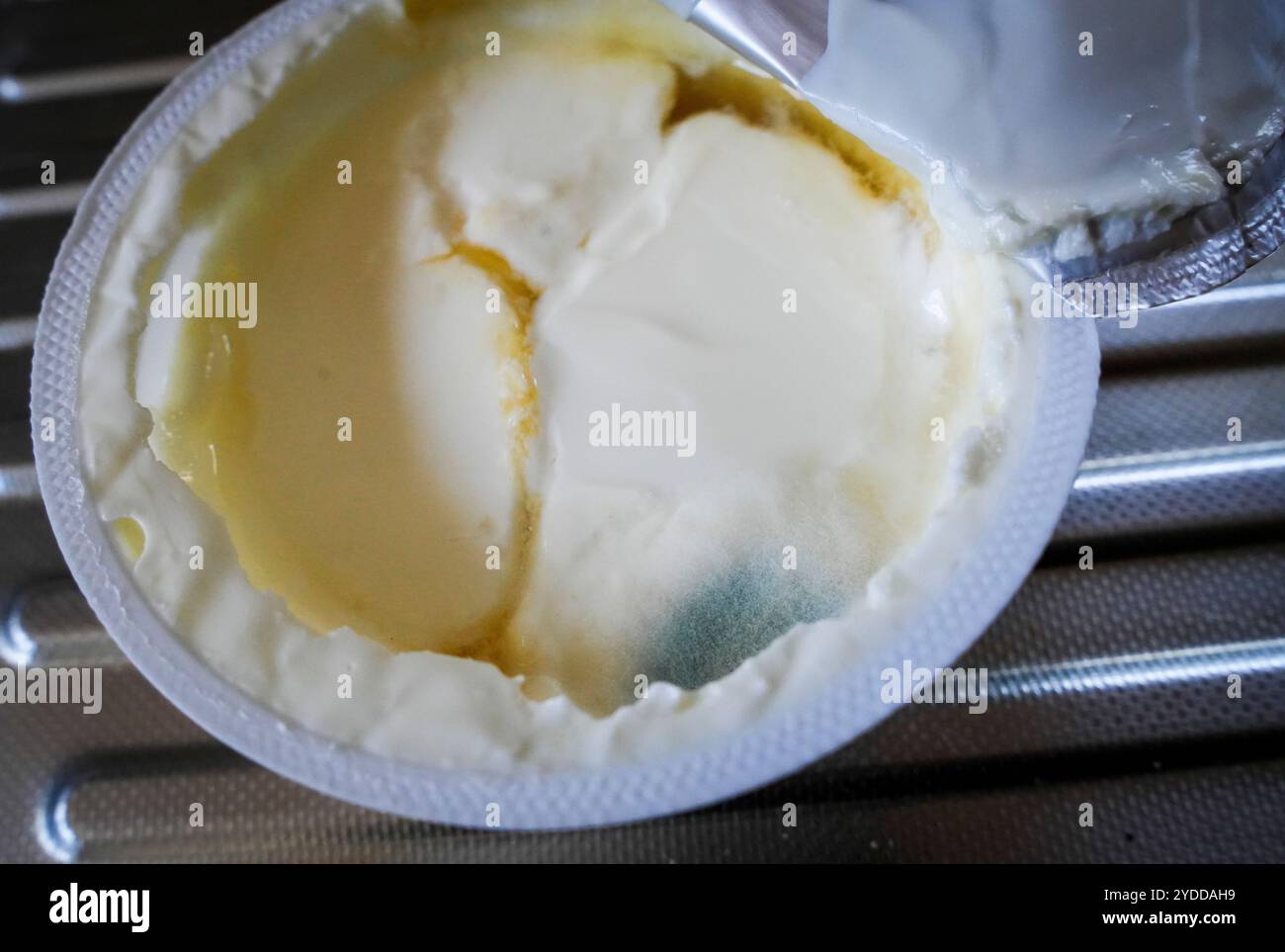 Product shoot detail close up of moldy uneadable yogurt in plastic ...