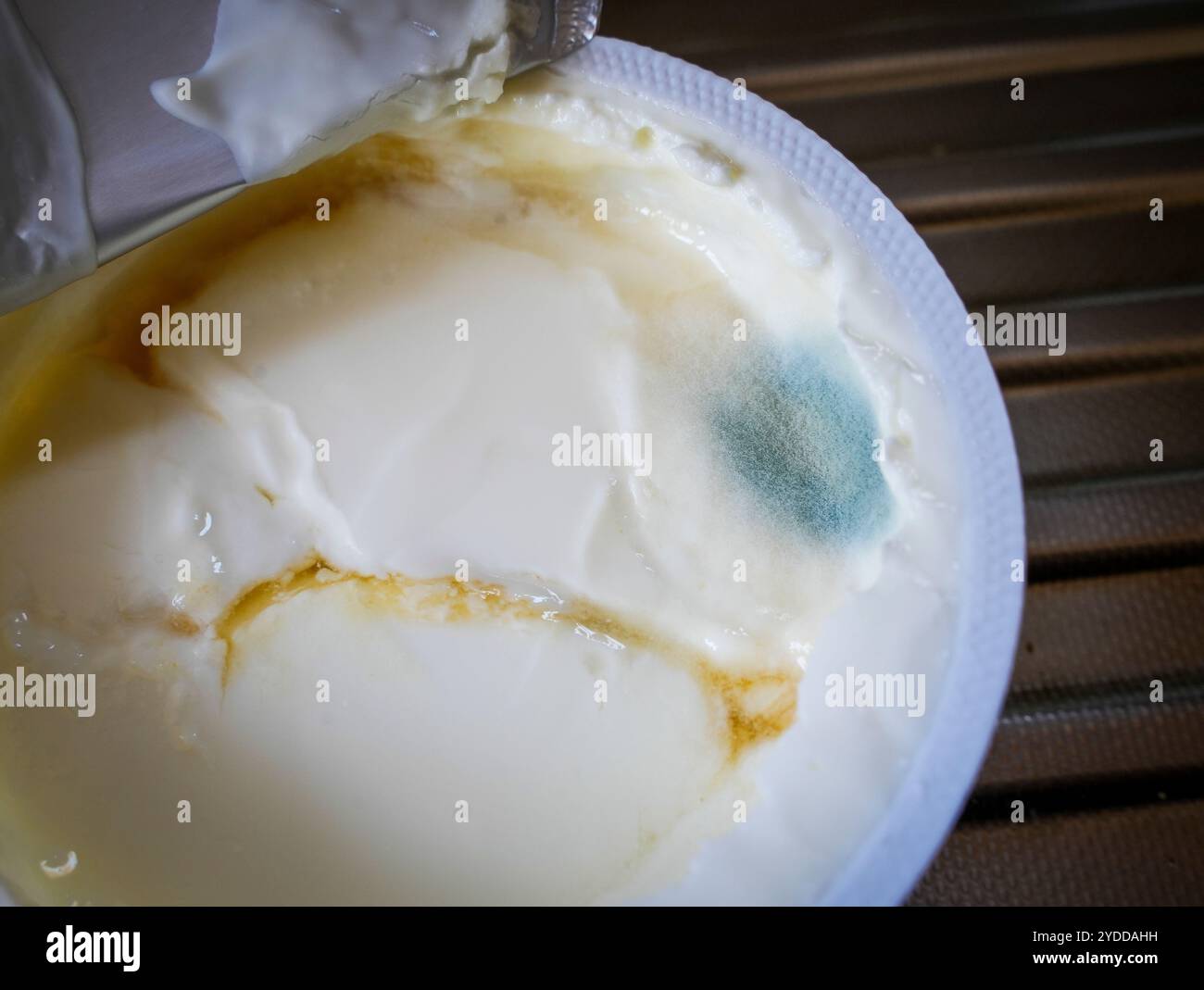 Product shoot detail close up of moldy uneadable yogurt in plastic ...