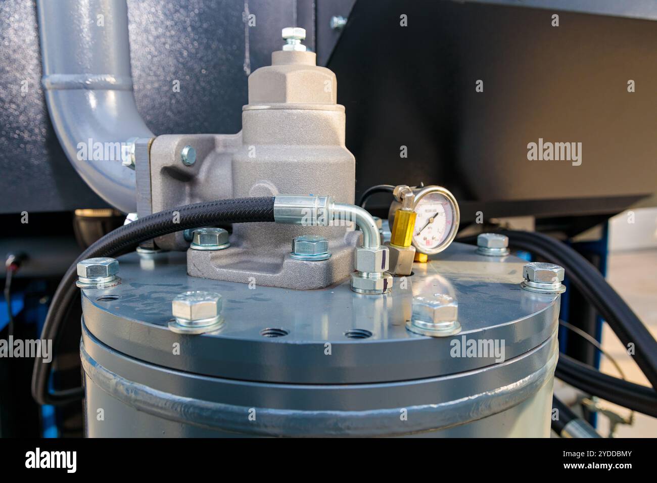 Close-up of industrial compressor showing pressure gauge, pipes, and ...