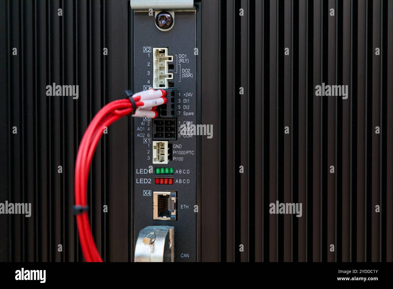 Red cable connecting to input output module of a programmable logic ... Red cable connecting to input output module of a programmable logic ...