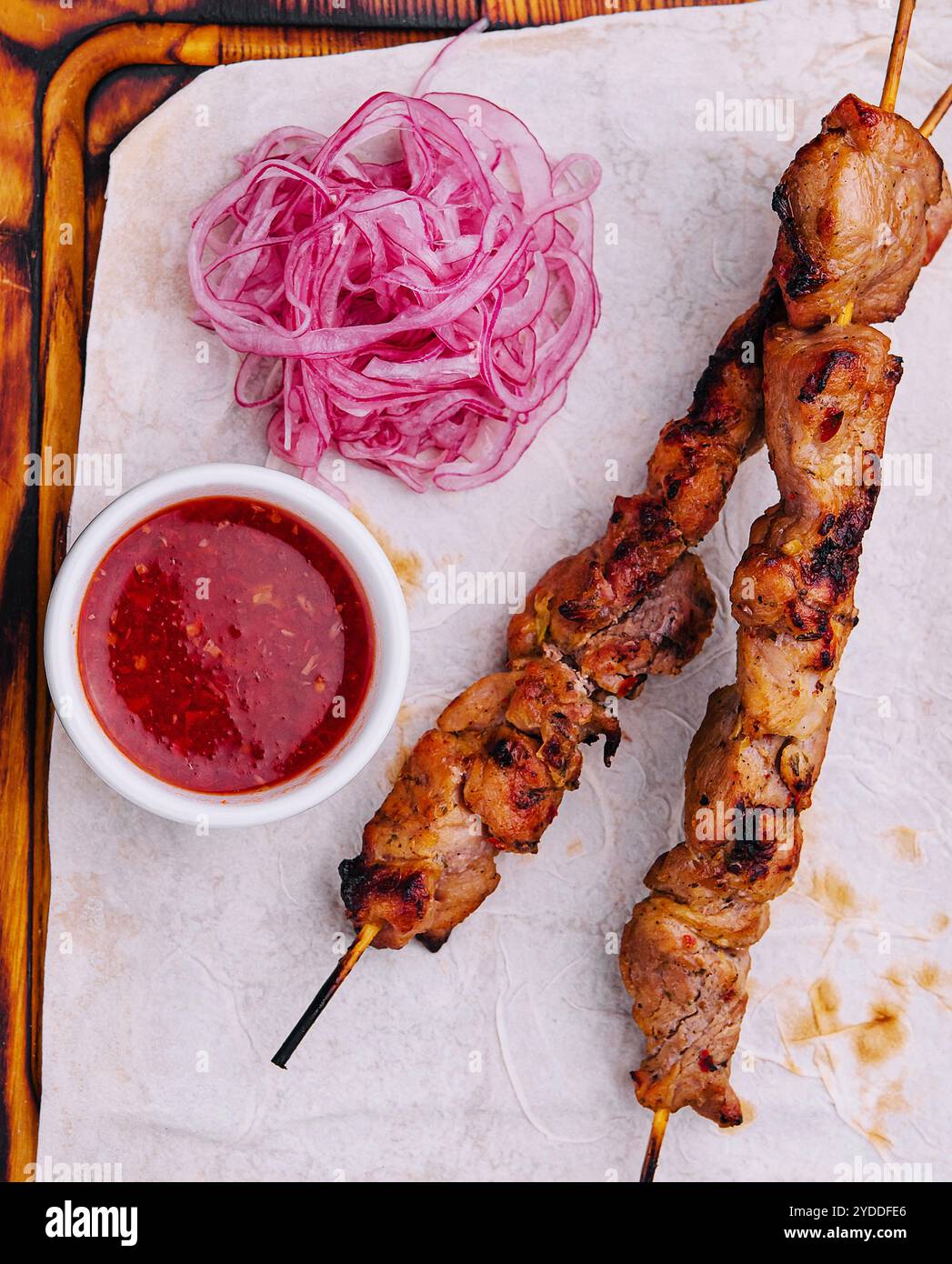 Pork kebab on a wooden skewer and red onion Stock Photo - Alamy