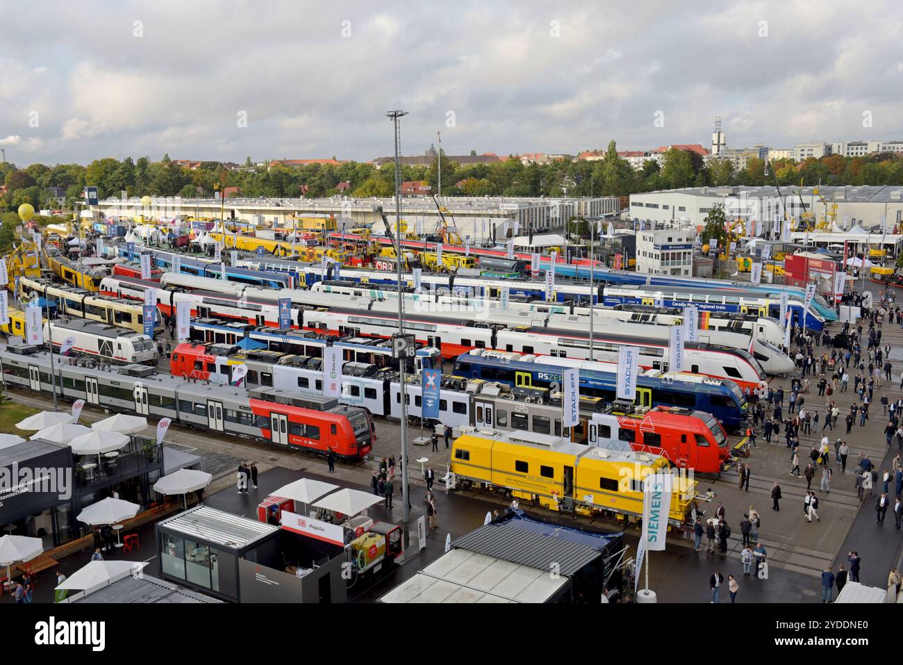People viewing new trains and locomotives in the outdoor display area at world public transport ...