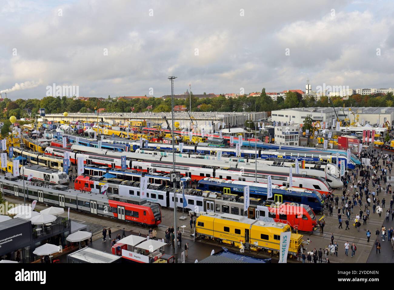 People viewing new trains and locomotives in the outdoor display area at world public transport ...