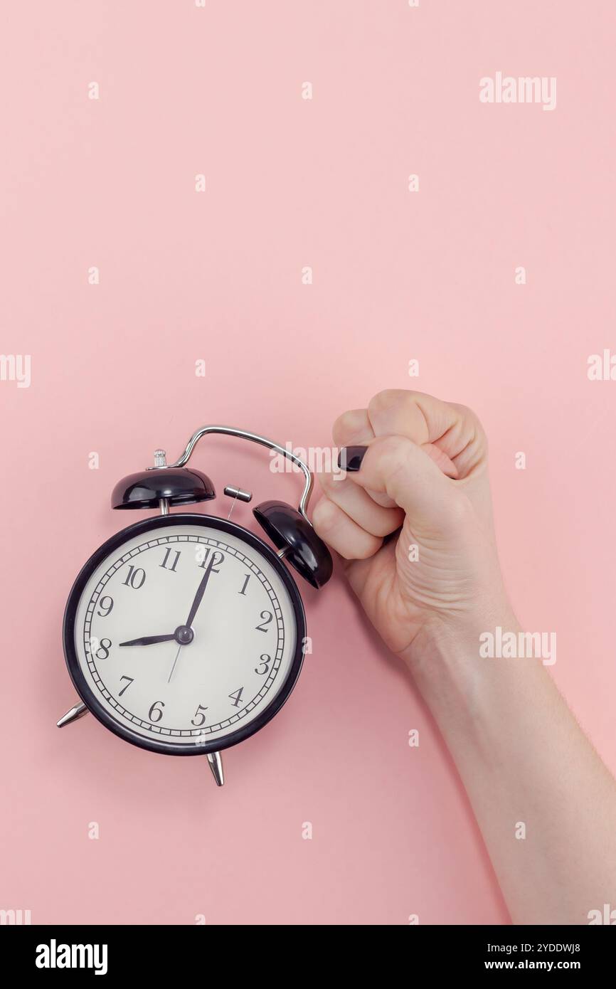Female hand with alarm clock. Morning concept Stock Photo - Alamy