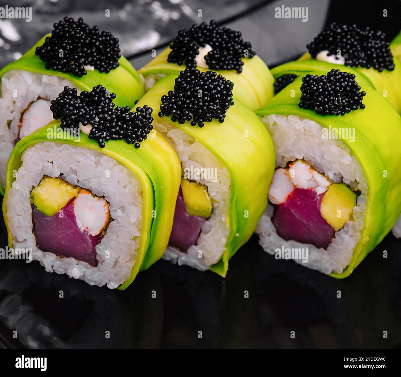 Sushi roll covered with avocado with tuna and black caviar Stock Photo ...