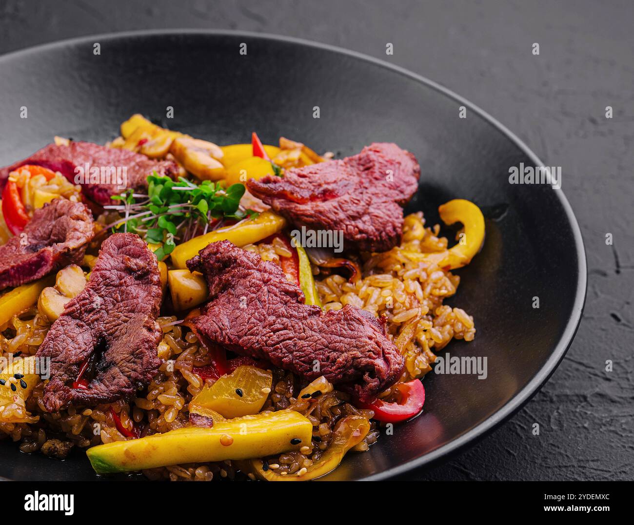 Chinese fried rice with beef on black plate Stock Photo - Alamy