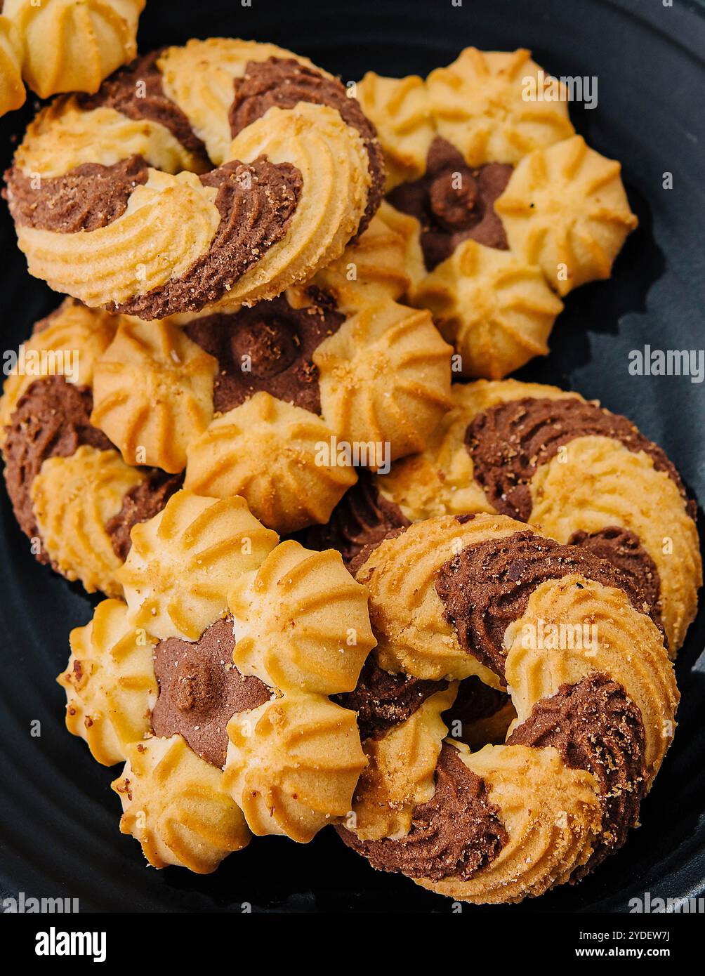 Crumbly cookies with chocolate on black plate Stock Photo - Alamy
