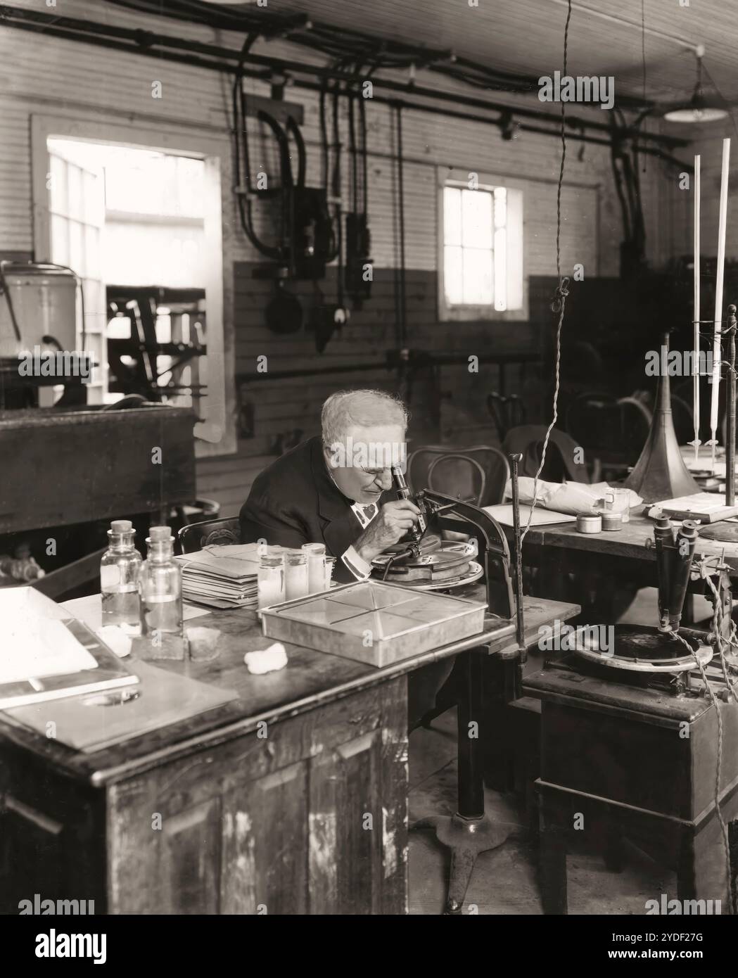 Thomas Alva Edison examining a phonograph disc under a microscope ...