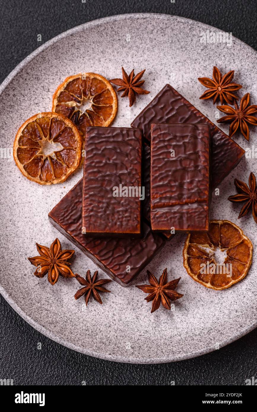 Rectangular chocolate candies with mousse and waffles on a dark ...