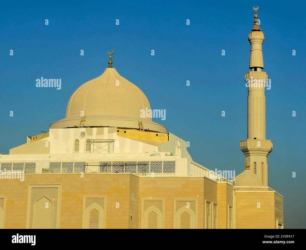 A high minaret and dome of a new mosque on a blue sky at the daylight ...