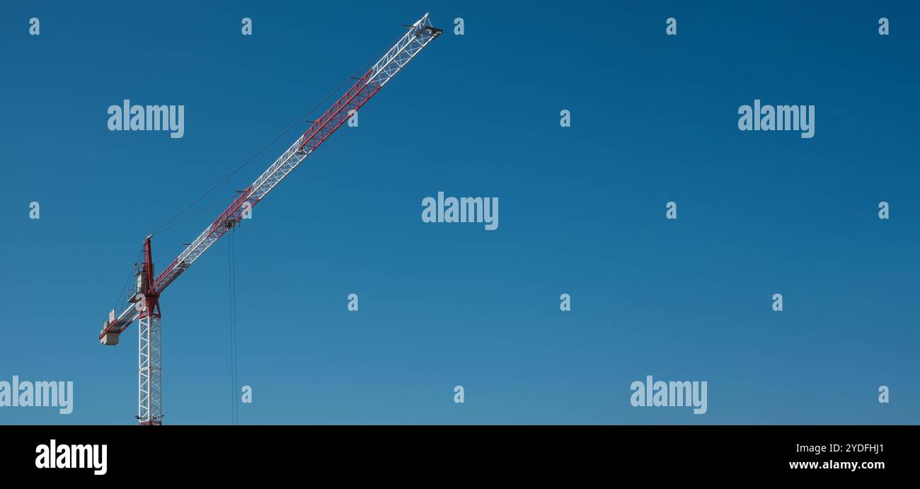 The crane works against the blue sky Construction, investment, real ...