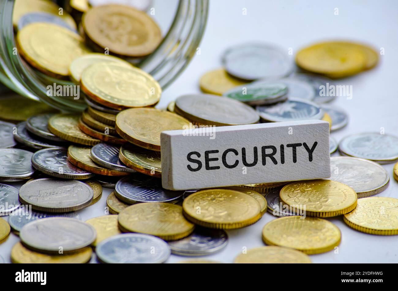 Security text on white wooden block with coins and jar background. Life ...