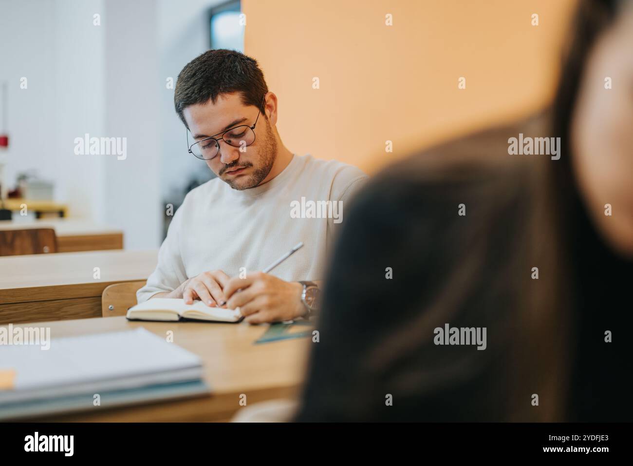 Focused high school student writing notes in classroom setting Stock ...