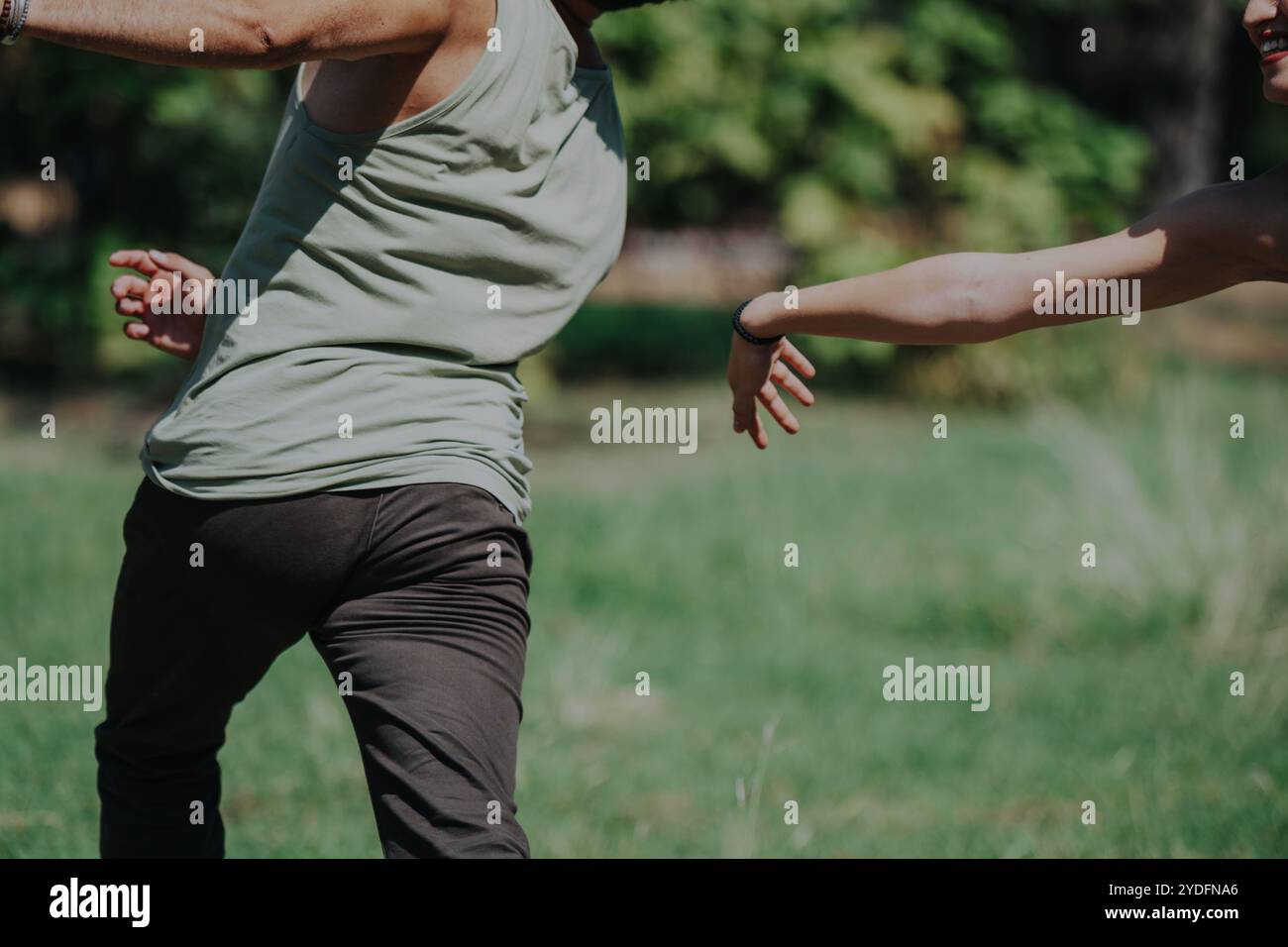 Two friends playing together joyfully in a sunny park, captured from a ...