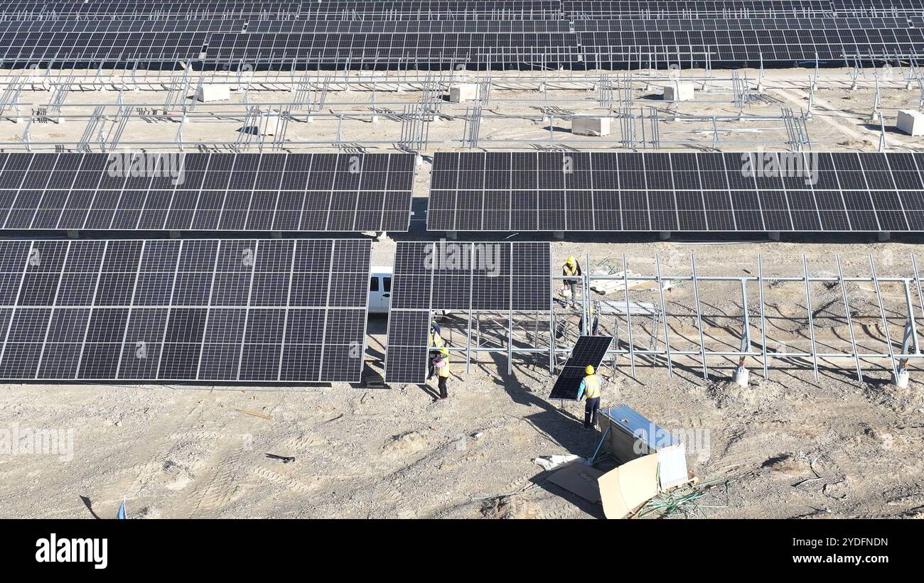 HAMI, CHINA - OCTOBER 26, 2024 - Workers install photovoltaic panels on ...
