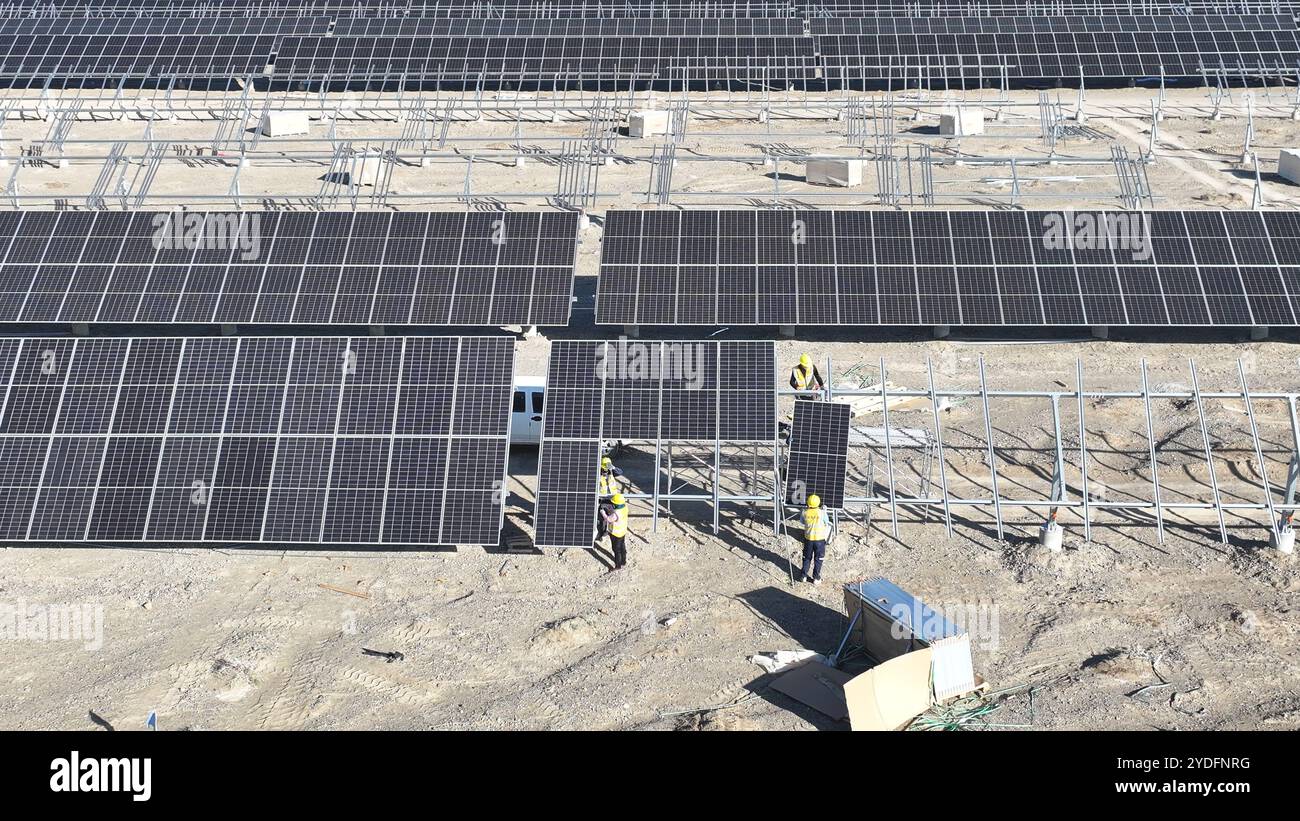 HAMI, CHINA - OCTOBER 26, 2024 - Workers install photovoltaic panels on ...