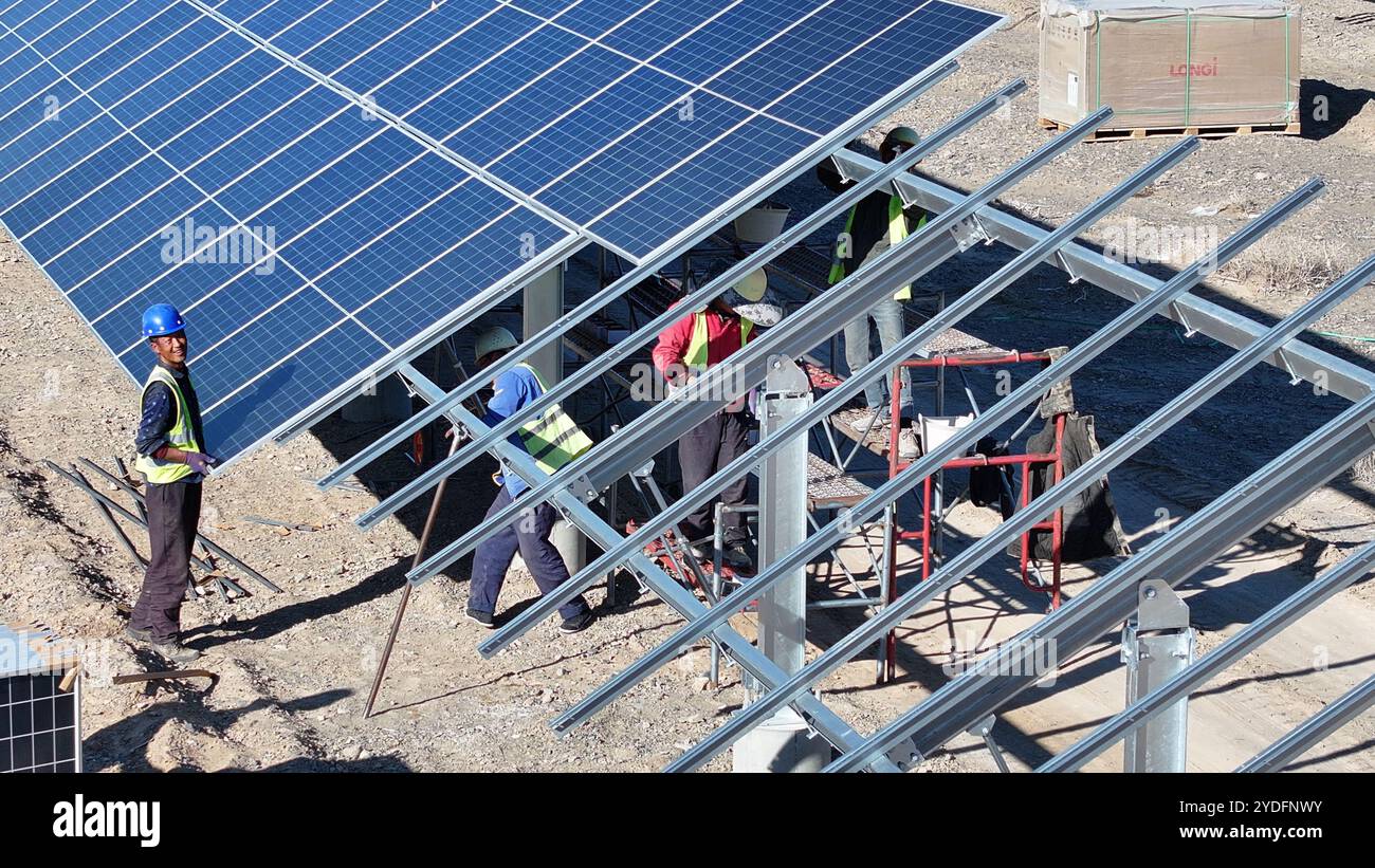HAMI, CHINA - OCTOBER 26, 2024 - Workers install photovoltaic panels on ...