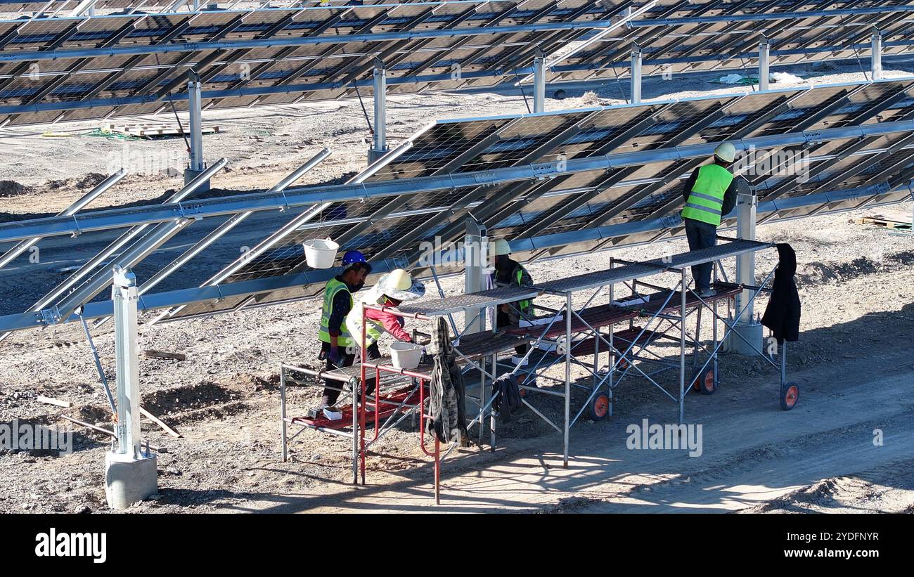 HAMI, CHINA - OCTOBER 26, 2024 - Workers install photovoltaic panels on ...