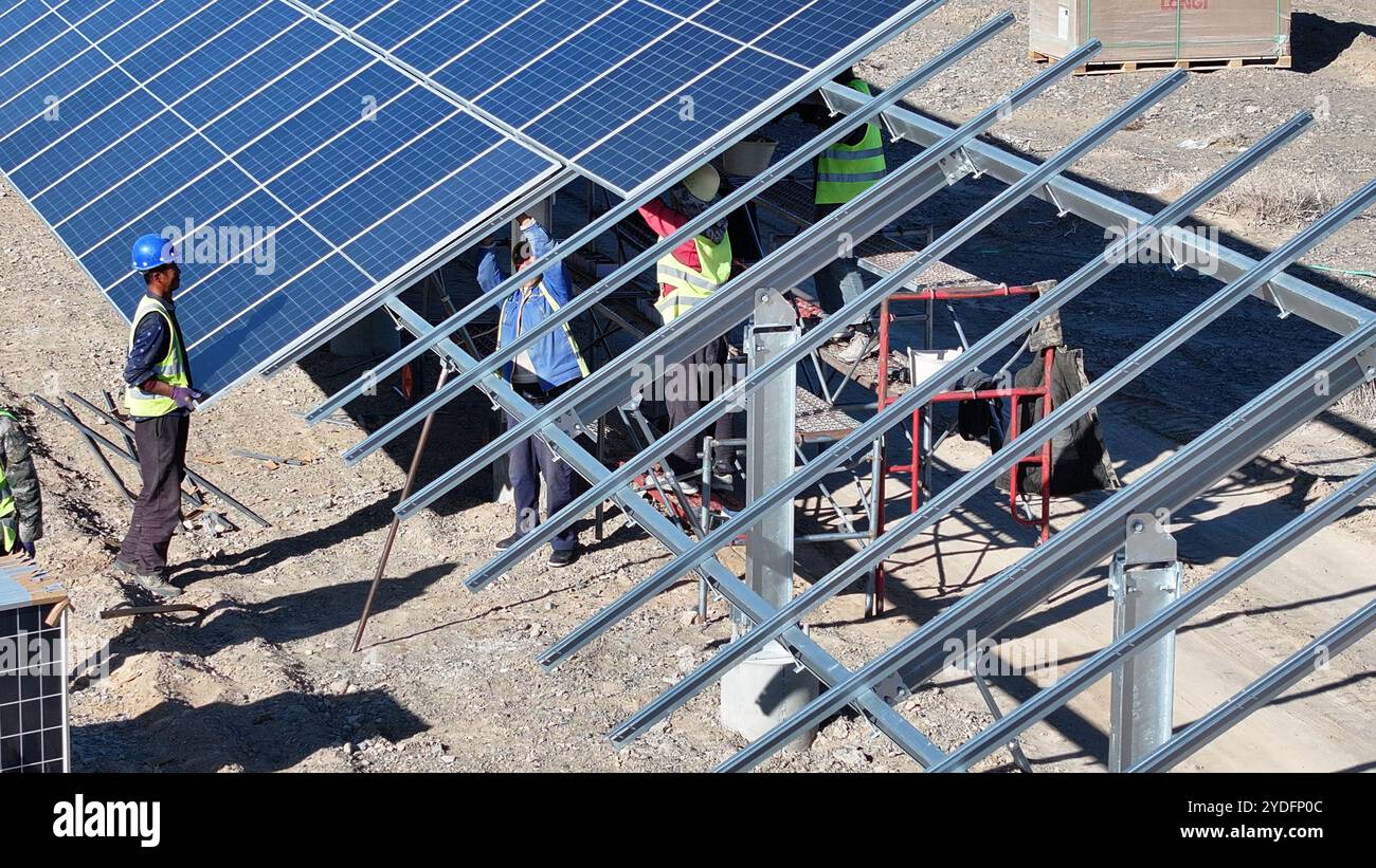 HAMI, CHINA - OCTOBER 26, 2024 - Workers install photovoltaic panels on ...