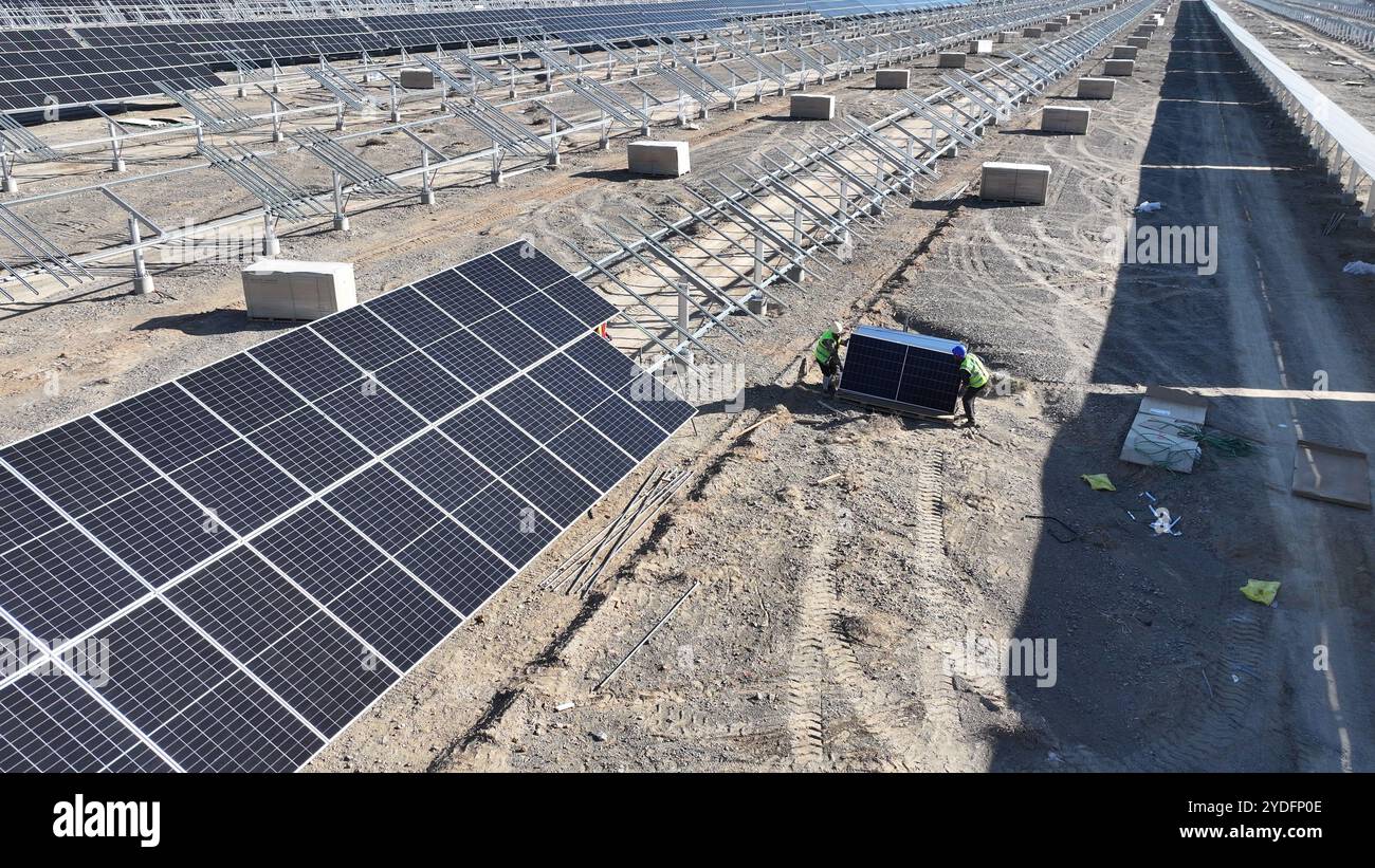 HAMI, CHINA - OCTOBER 26, 2024 - Workers install photovoltaic panels on ...