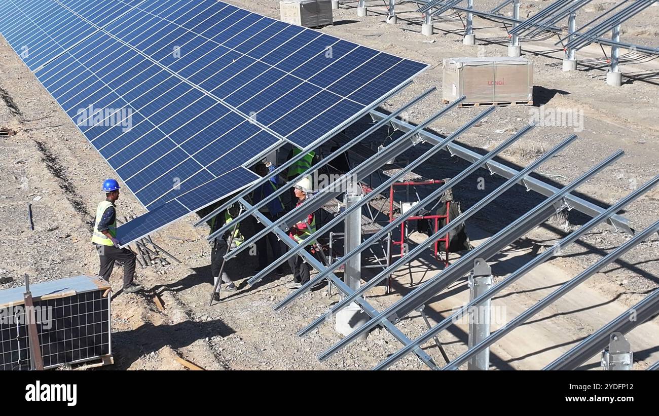 HAMI, CHINA - OCTOBER 26, 2024 - Workers install photovoltaic panels on ...
