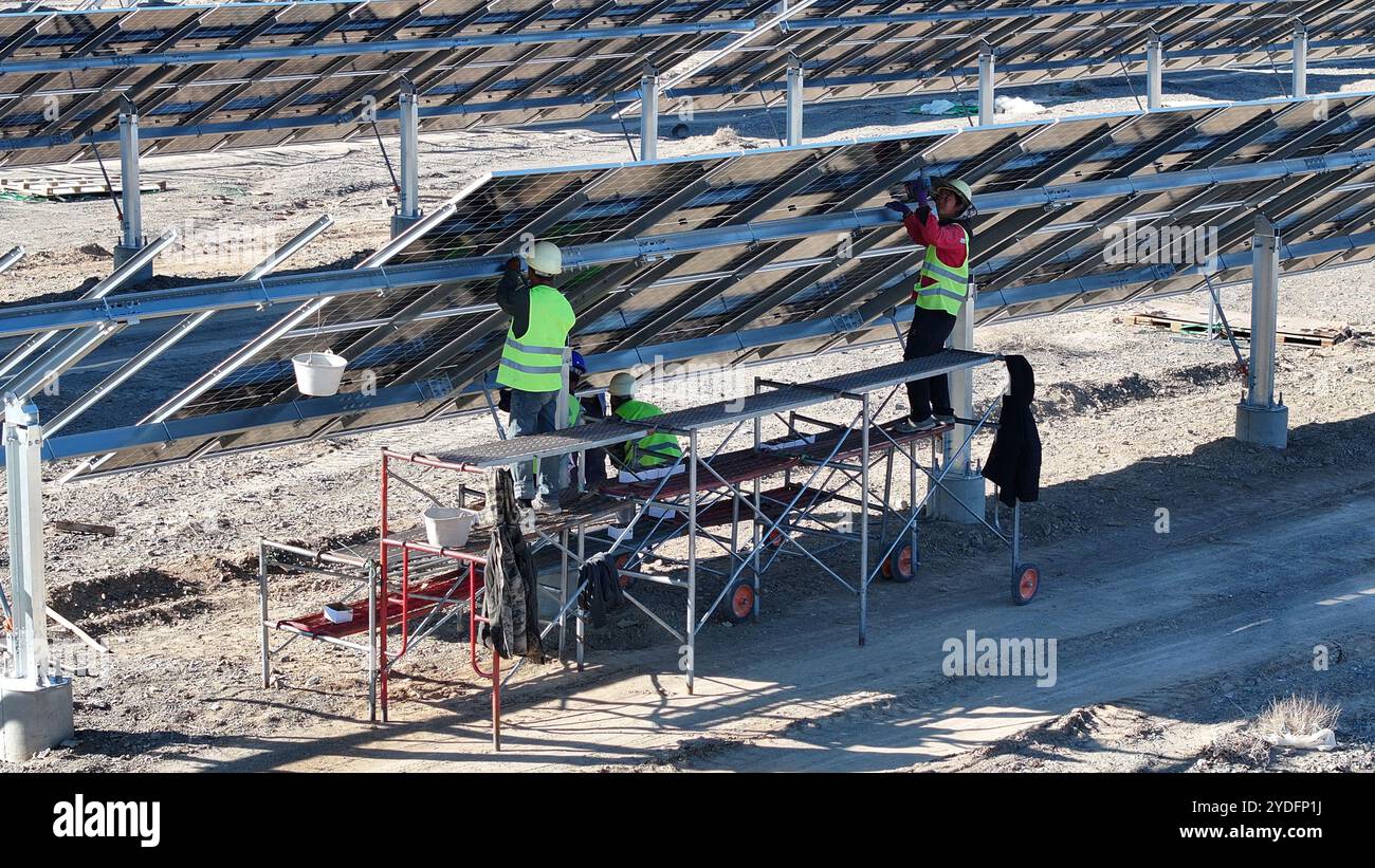 HAMI, CHINA - OCTOBER 26, 2024 - Workers install photovoltaic panels on ...