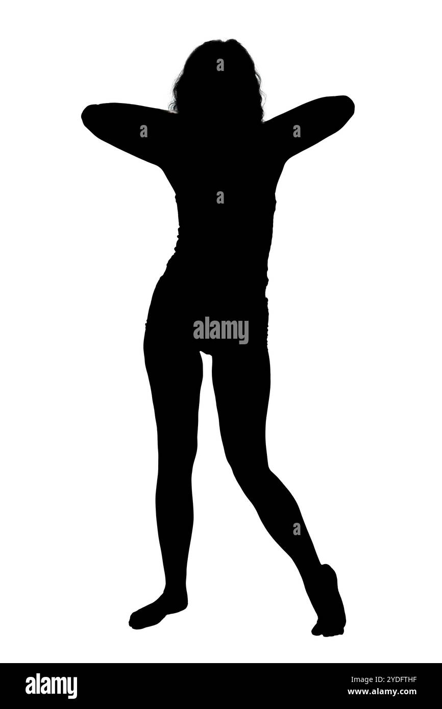 The graceful silhouette of a woman is dancing joyfully with her arms ...