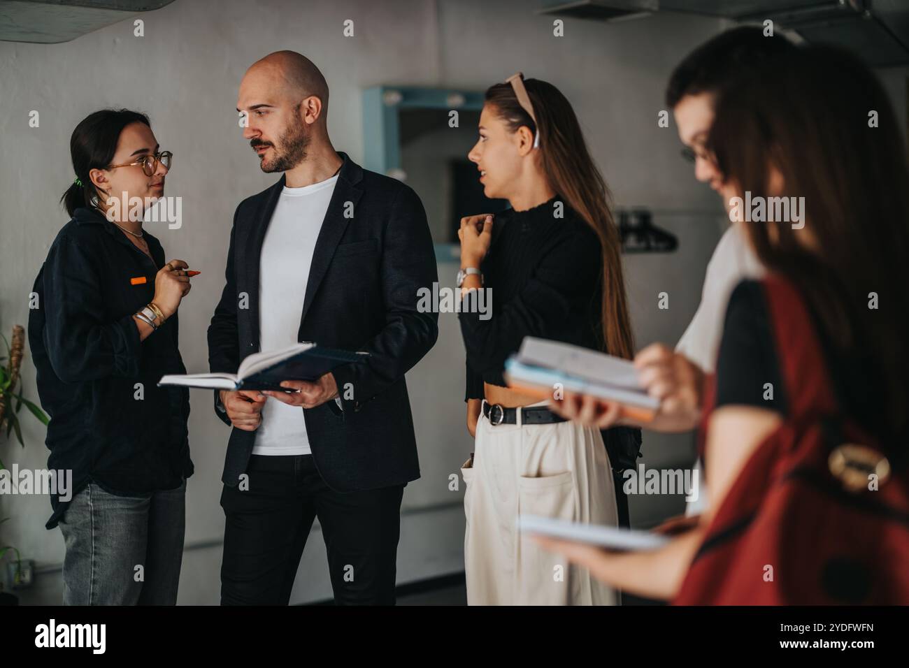 Group of students consulting professor in university hallway Stock ...