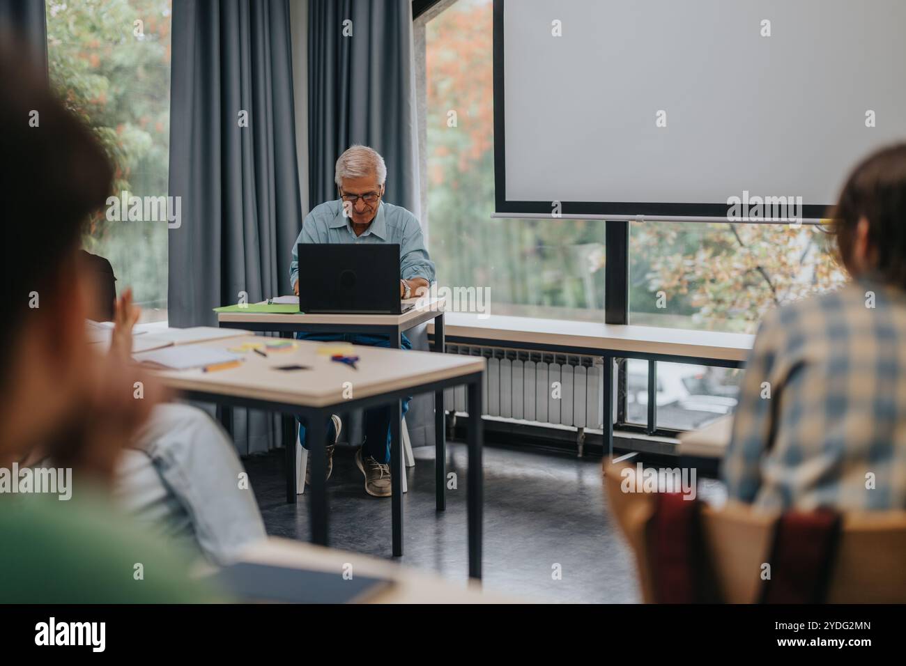 Elderly professor teaching students in a modern classroom setting Stock ...