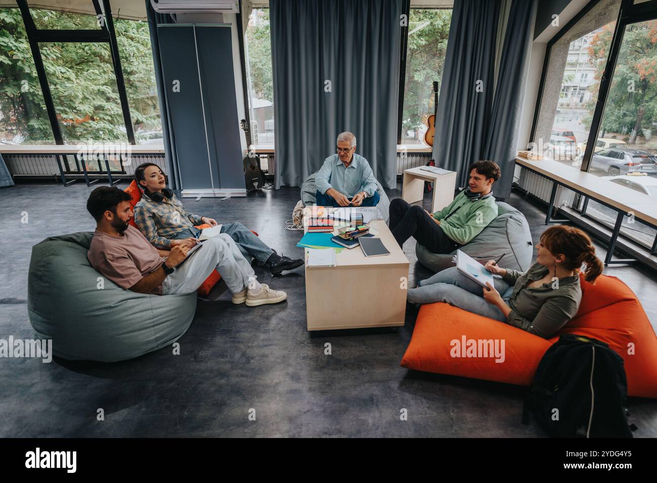 Professor engaging with students in a modern study lounge setting Stock ...