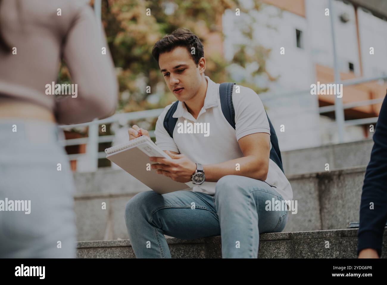 Students studying together outdoors in urban setting after classes ...