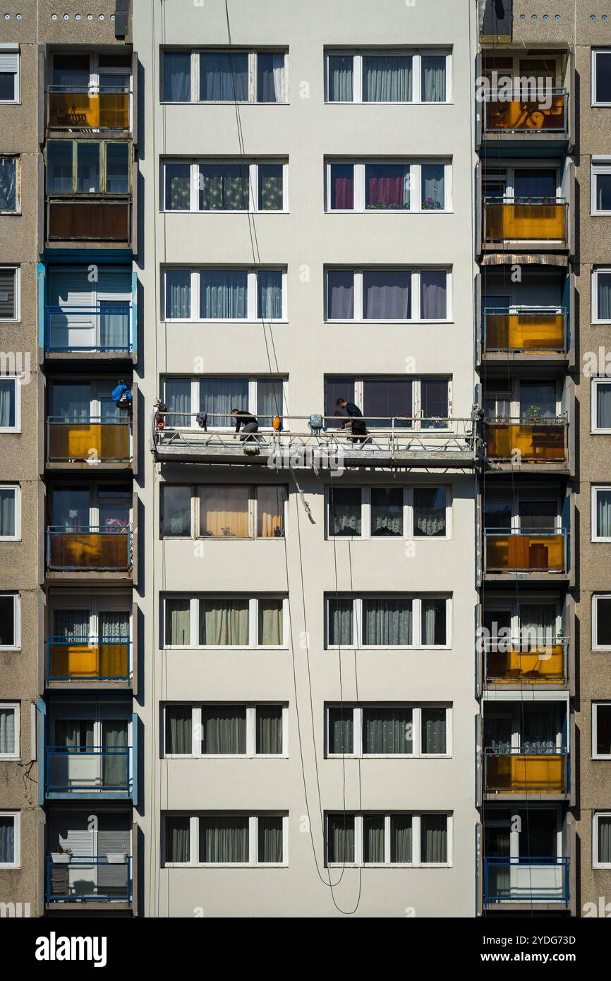 Budapest, Hungary - Workers standing on a suspended platform painting ...