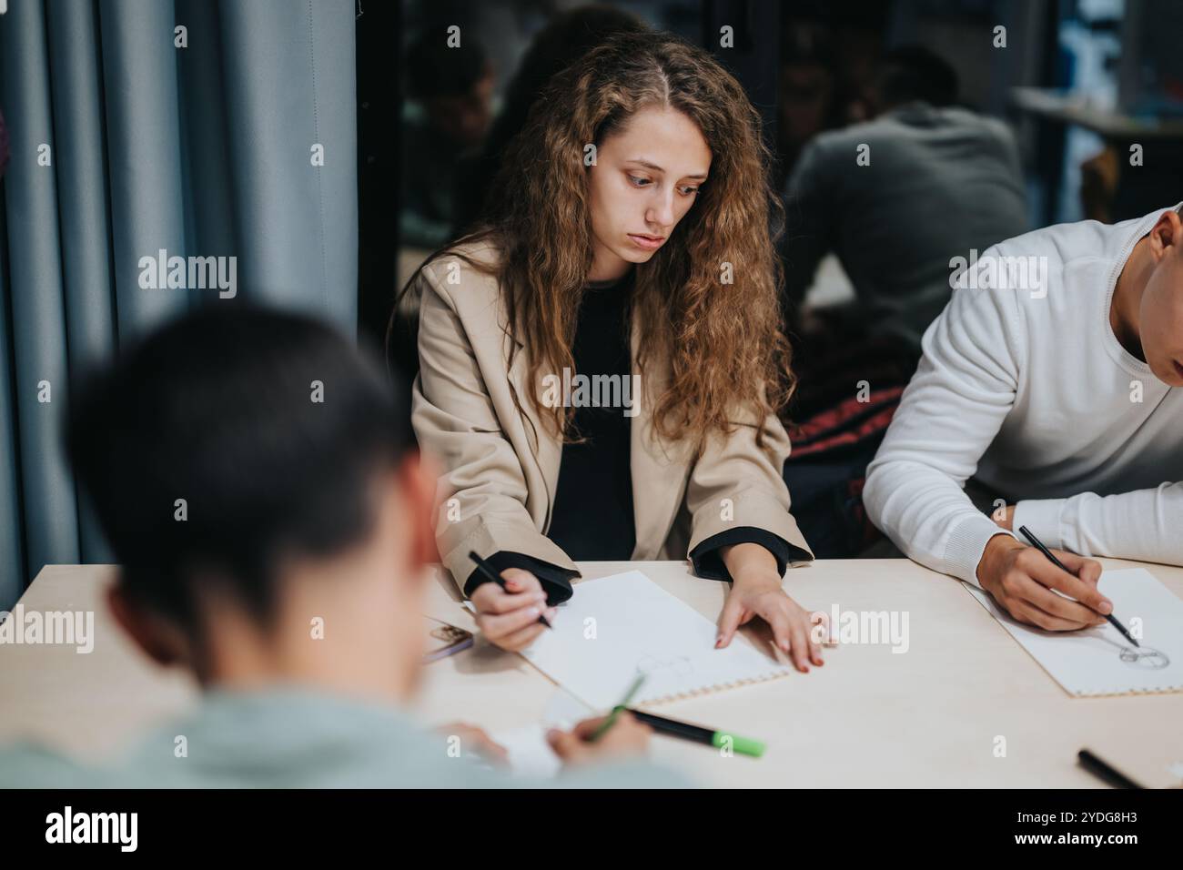 Students focusing on drawing tasks in a creative classroom setting ...