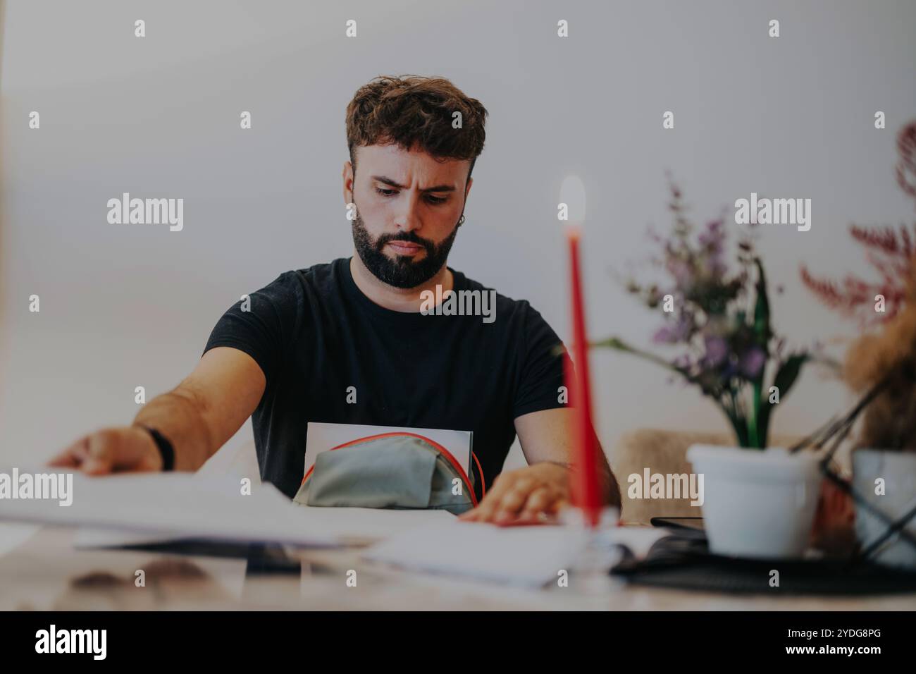 Focused college student studying at home with lit candle Stock Photo ...
