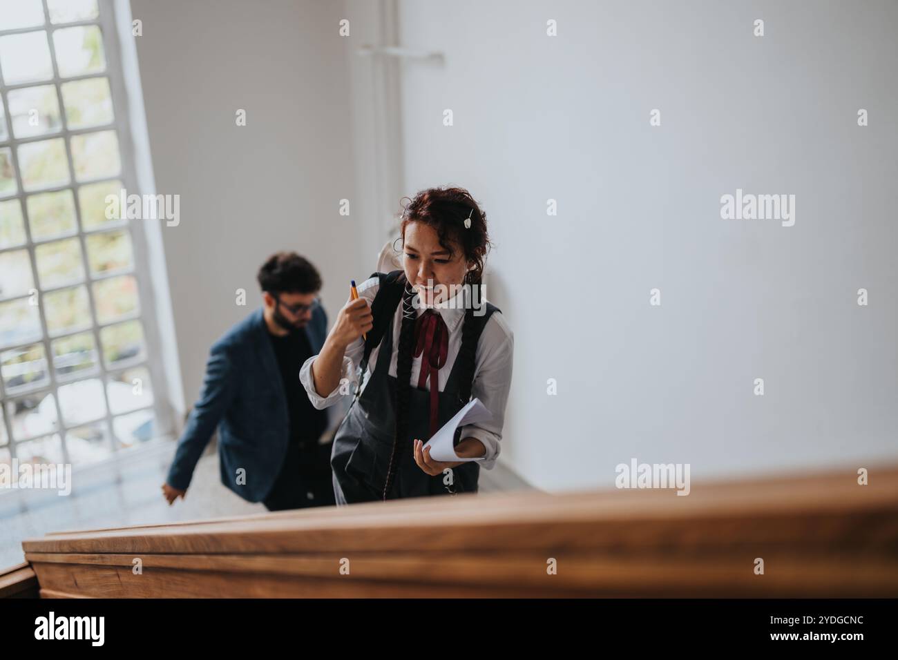 Two students walking up stairs in academic building hallway Stock Photo ...