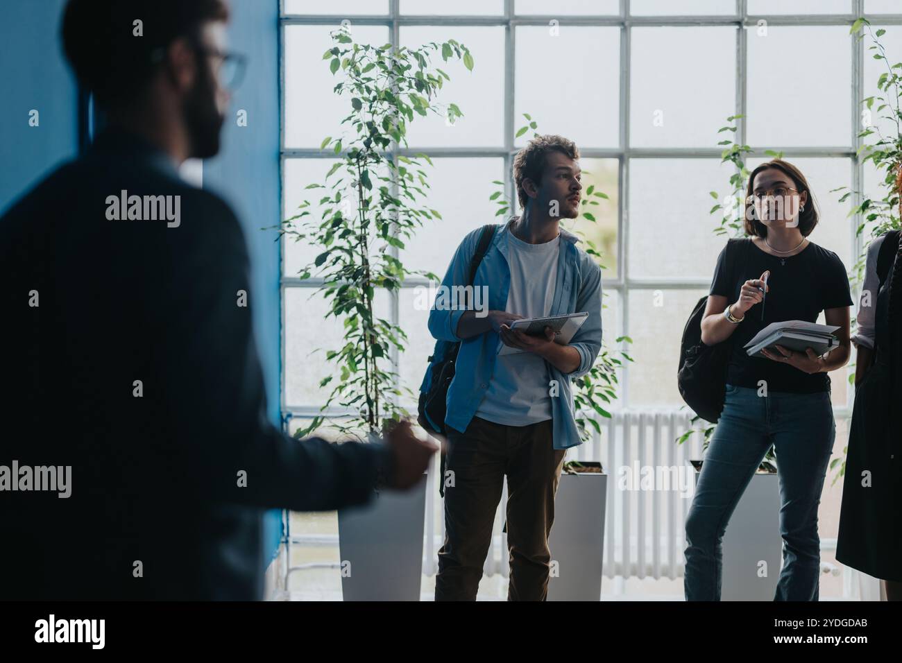 Group of students engaged in discussion with a professor Stock Photo ...
