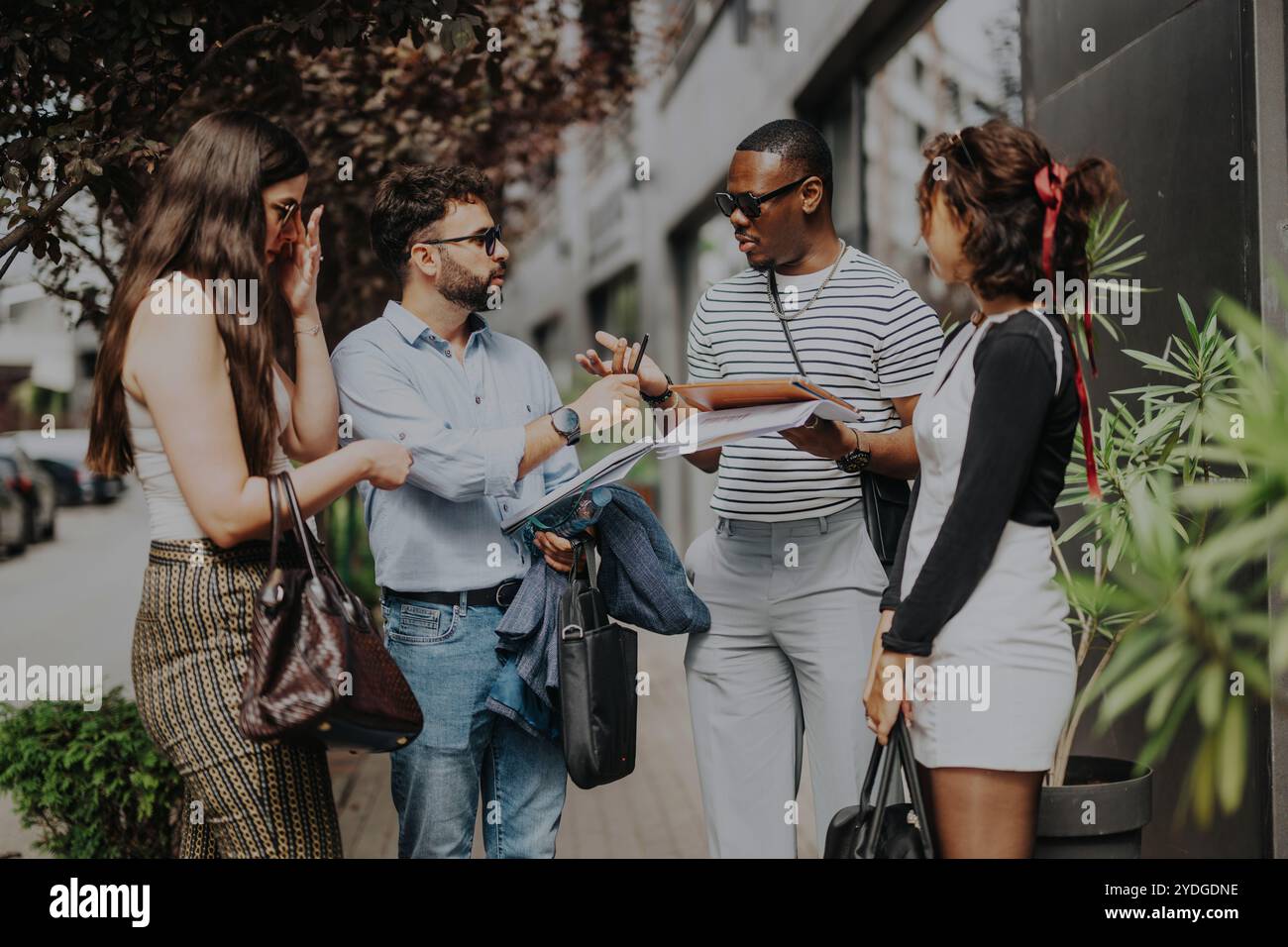 Group of young people collaborating outdoors in urban setting Stock ...