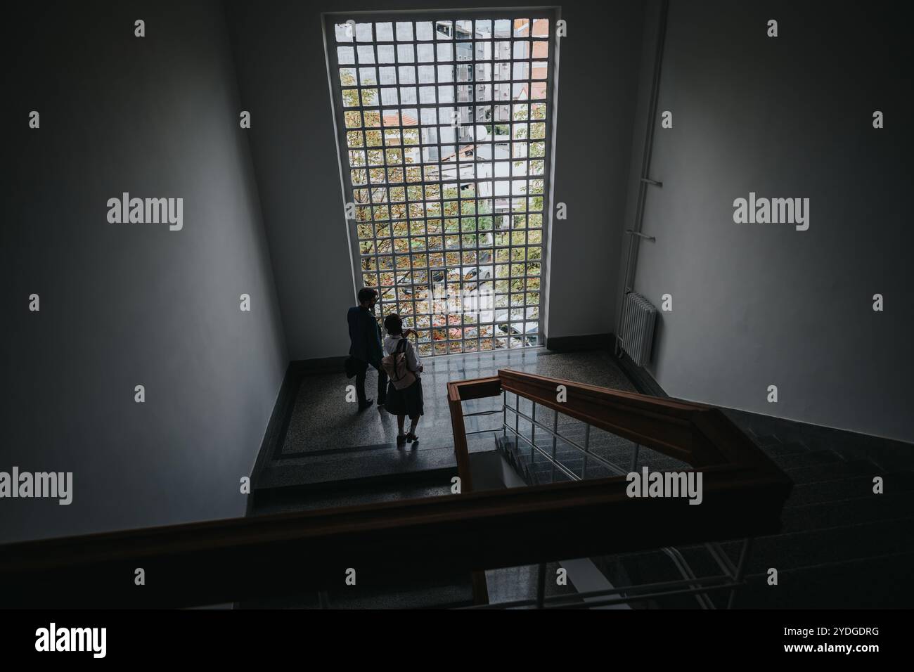 Students engaging with professor in modern university hallway Stock ...