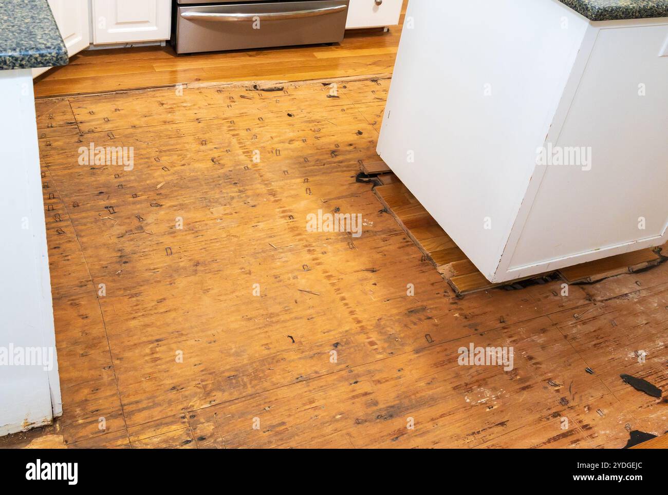 Hardwood floor pulled up after water damage with damage to adjacent ...