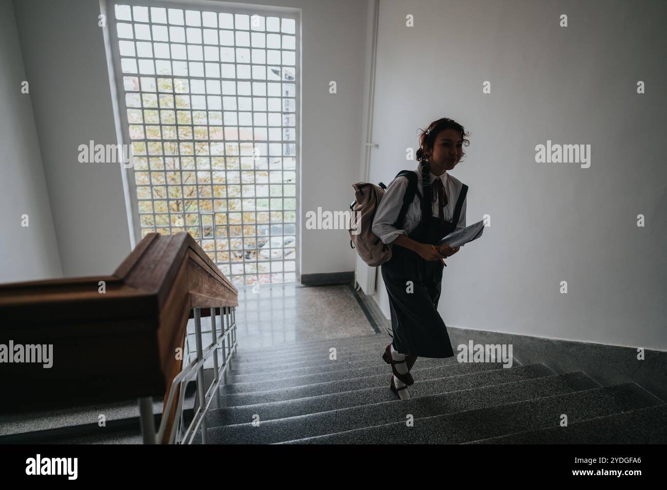 Student ascending staircase in a dimly lit academic building Stock ...