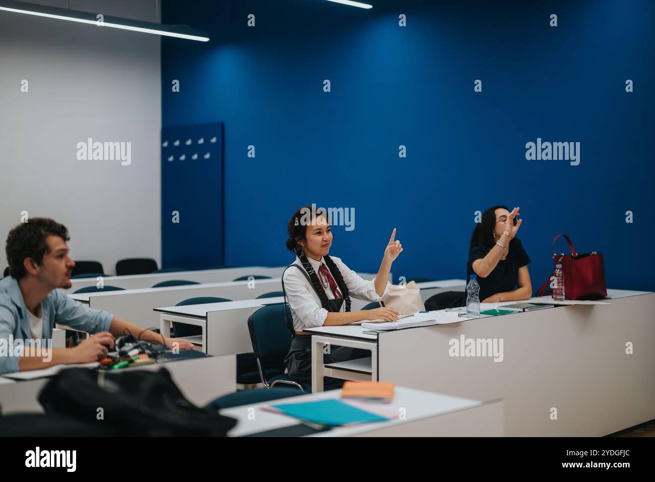 University students in classroom participating in a lecture session ...