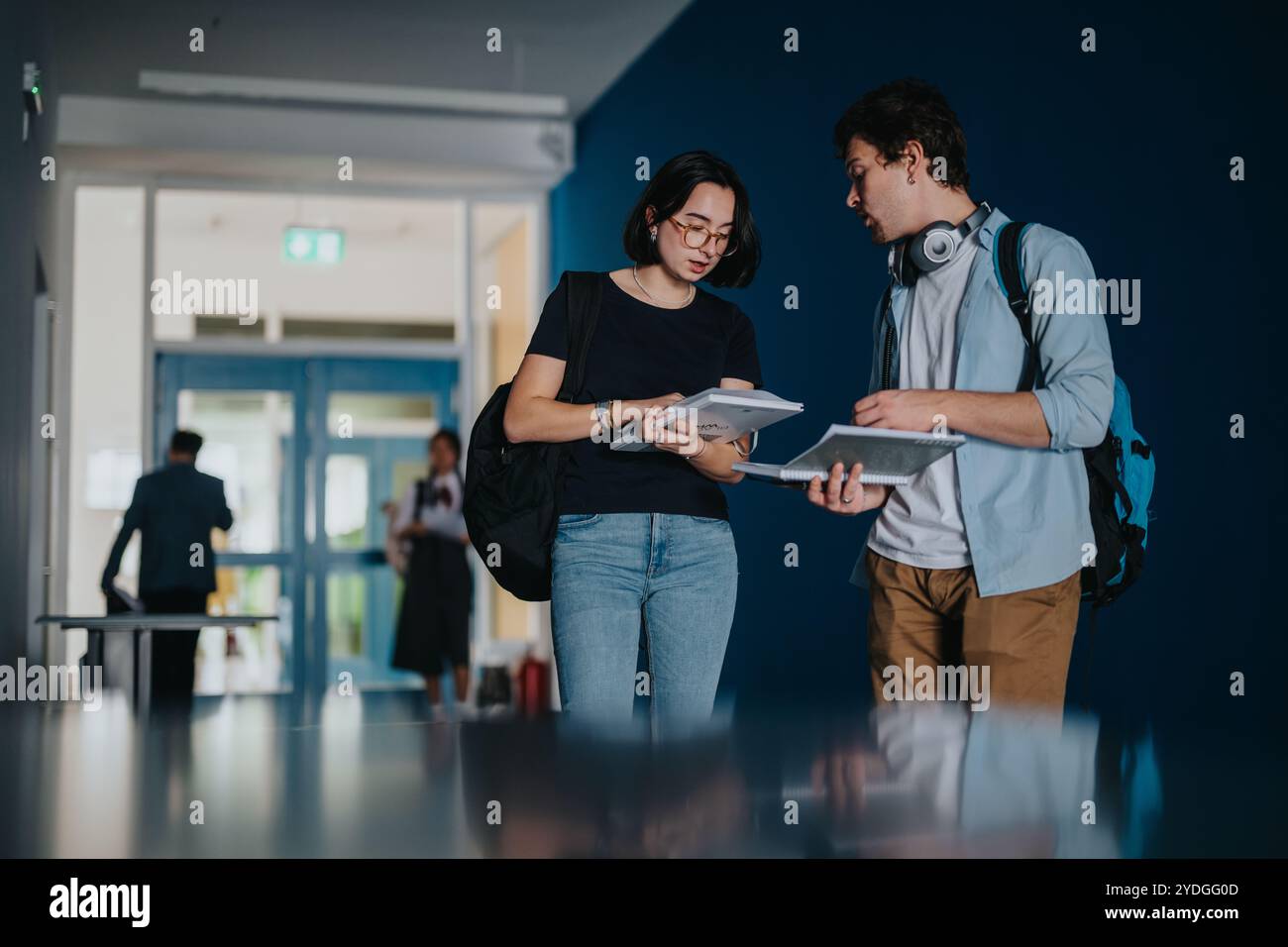Students conversing in school hallway during class break Stock Photo ...